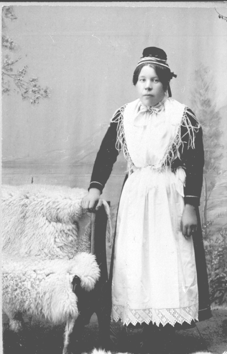 Studioportrett av kvinne i helfigur med samisk drakt. -Sør-Troms Museum ...