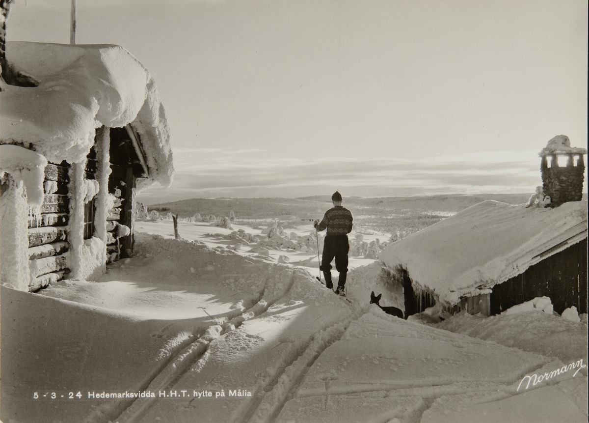 Postkort, Løten, Hedmarksvidda H.H.T. hytte på Målia, vinter. mann på ...