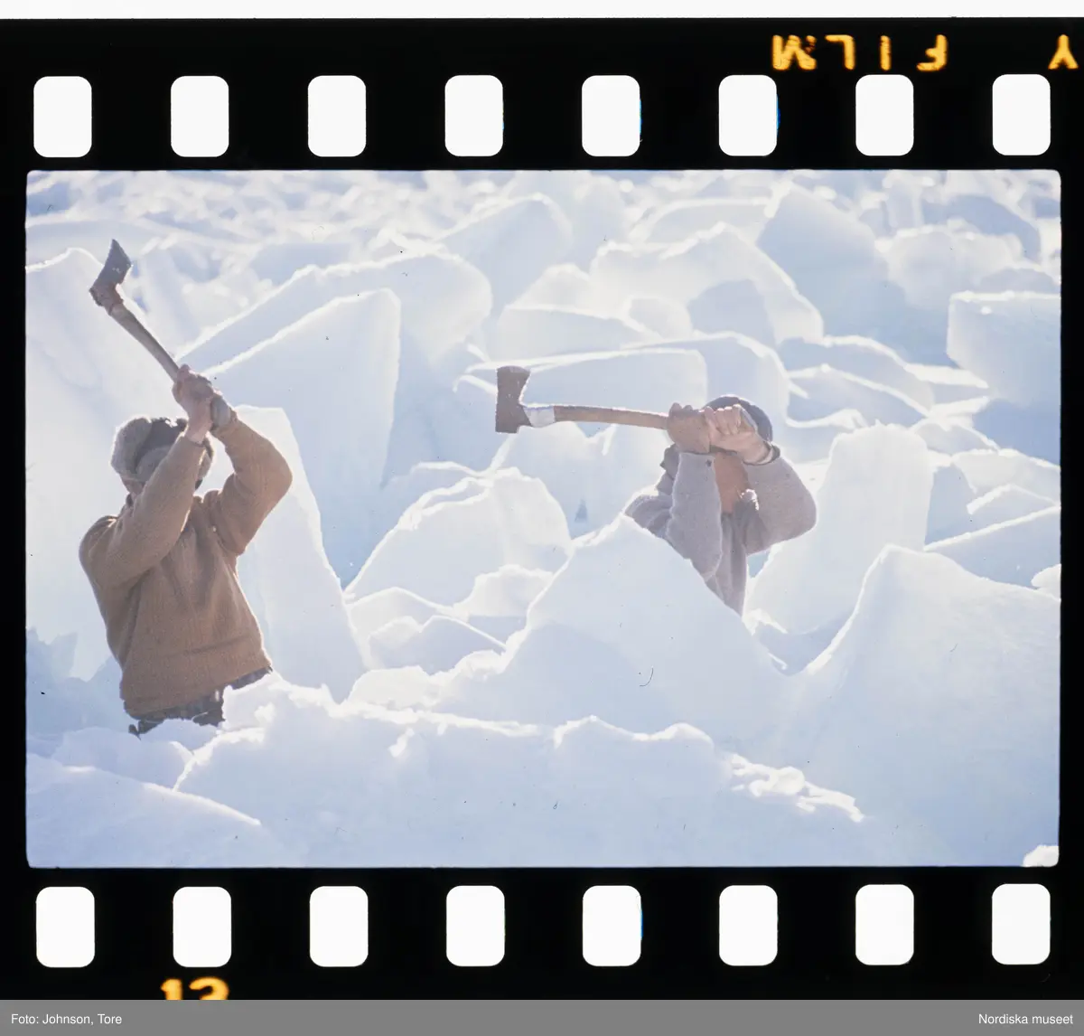 Man hugger ner isflak för att plana till en väg för båt och utrustning ...