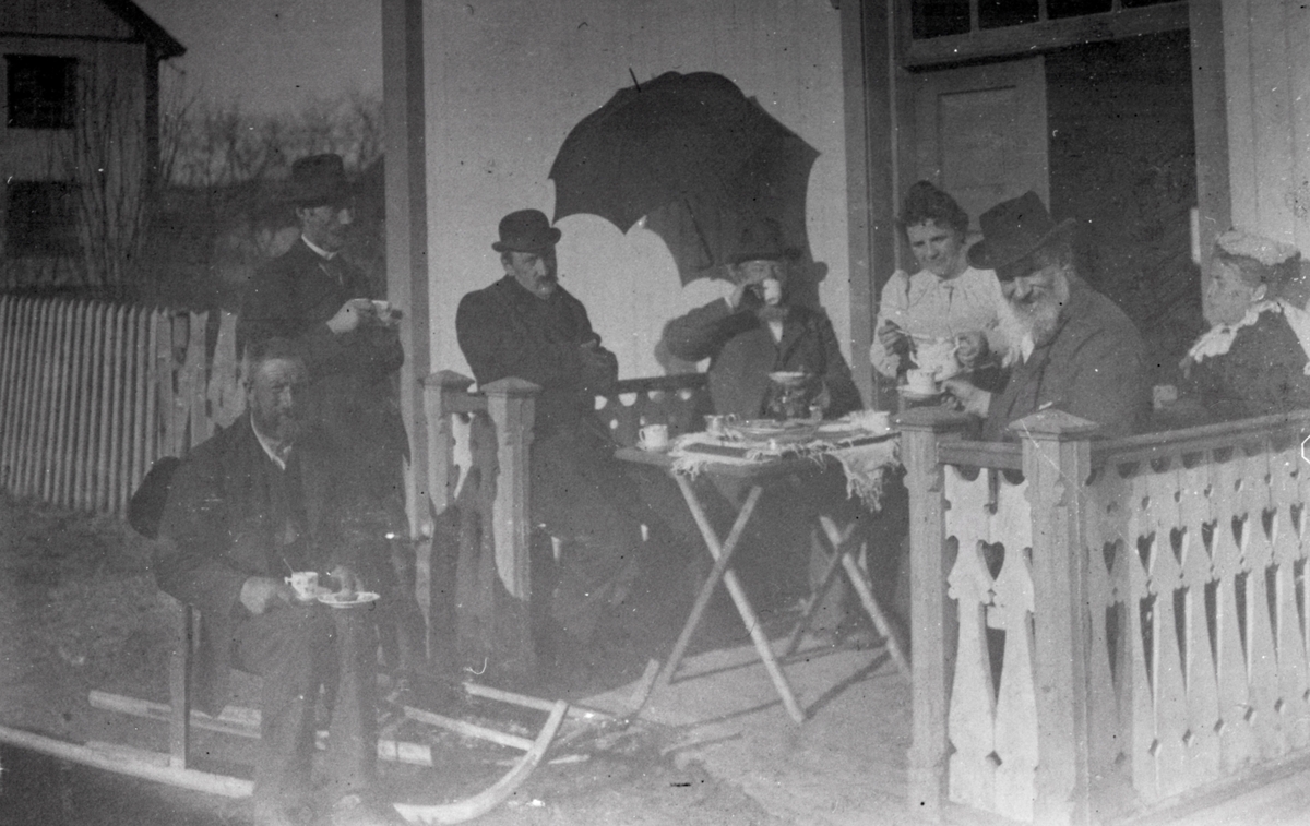 Motiv av familien Aston som drikker kaffe ute på terrassen ved Byrud ...