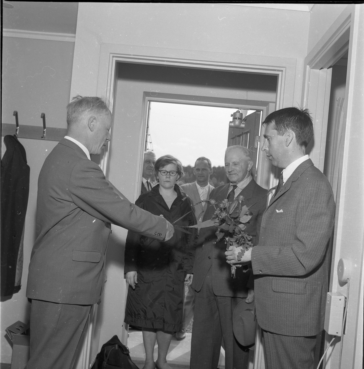 Innanför en dörr står Erland Skoog till vänster och bankdirektör Tom ...