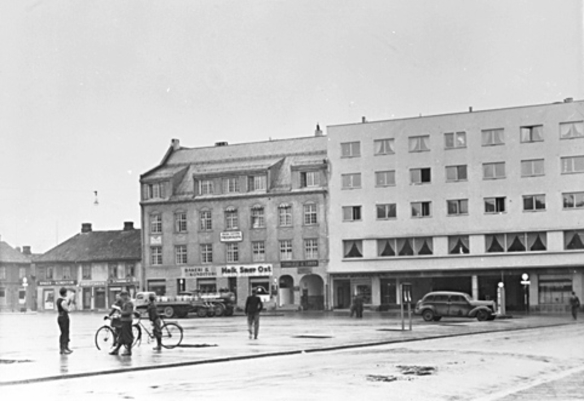 Hamar, Østre Torg, gruppe med sykkel på torget, bak: huset til Baker E ...